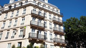 Um hotel de vários andares com varandas, grandes janelas e estilo arquitetônico clássico.