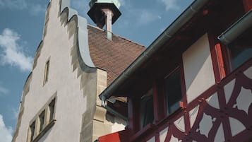 Um edifício com uma torre e uma varanda com estrutura vermelha.