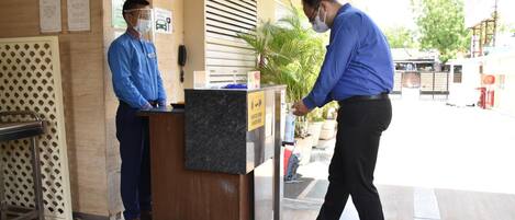 Uma receção com um homem de camisa azul e calças pretas ao lado de outro homem de camisa azul e calças escuras.