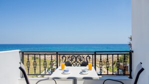 Varanda com mesa posta para dois, com vista para a praia e o mar.