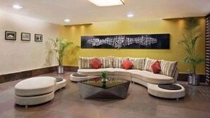 Uma sala de estar moderna com um sofá curvo, uma mesa de centro de vidro e almofadas decorativas.