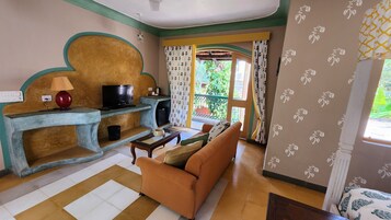 Uma sala de estar com sofá, televisão e lareira.