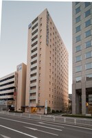 Hotel com vários andares e placa de estacionamento 'P' bem visível, indicando disponibilidade de estacionamento no local.