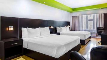 Quarto de hotel com duas camas, uma escrivaninha e uma cadeira.