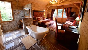 Uma cabana de madeira com banheiro, um quarto com cama grande e uma sala de jantar.