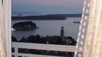 Vista da janela sobre um corpo de água, com uma ilha distante e uma torre.