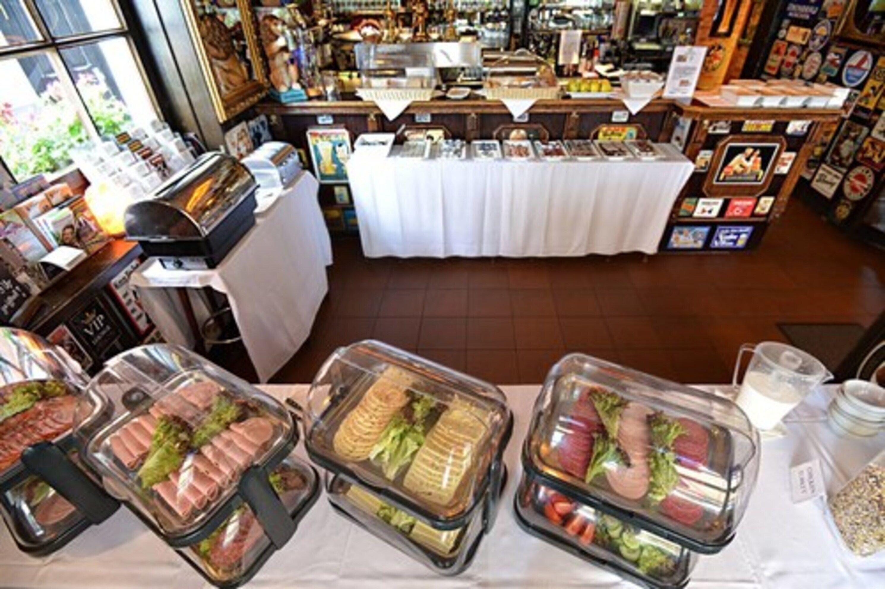 Disposição de buffet com diversos alimentos e uma máquina de café.