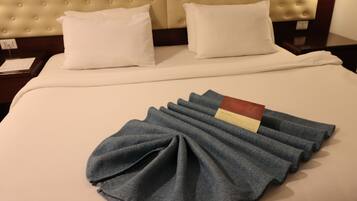 Cama bem arrumada com toalha dobrada e etiqueta.