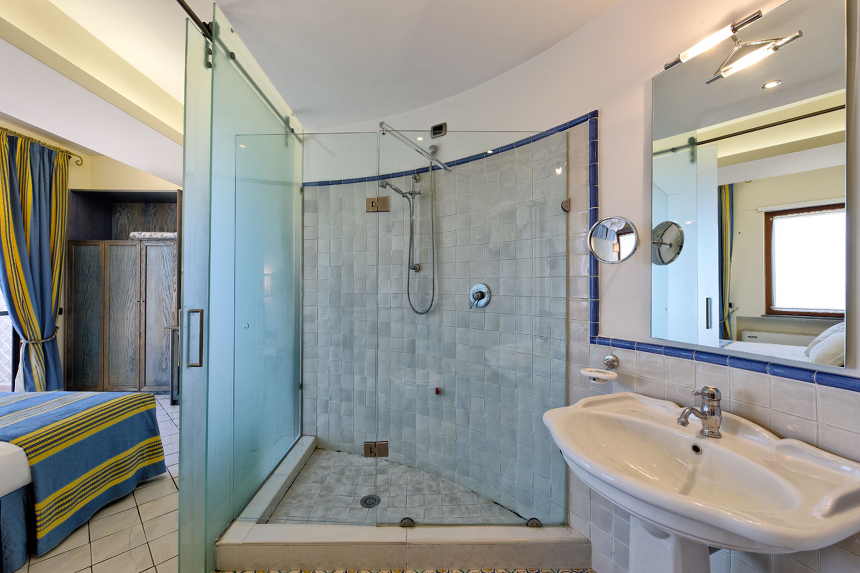 Uma casa de banho moderna com cabine de duche em vidro, lavatório e espelho.