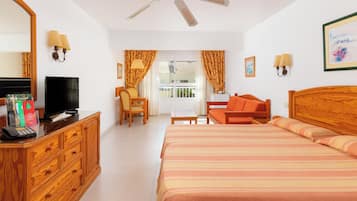 Quarto de hotel com cama, televisão, escrivaninha e cadeira.