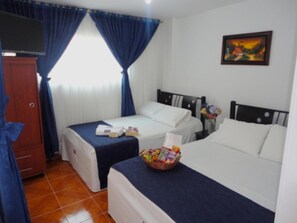 Quarto de hotel com duas camas, uma televisão e um quadro na parede.
