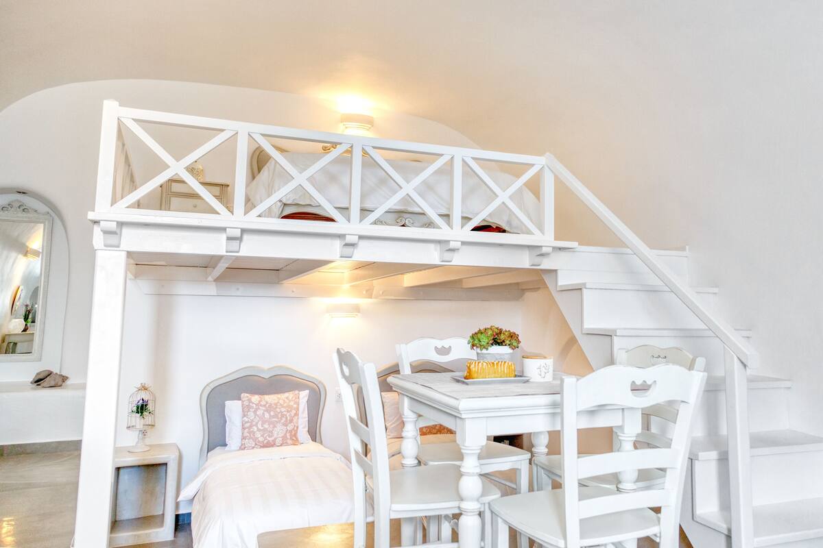 Quarto com beliche, uma mesinha com uma planta e uma cadeira.