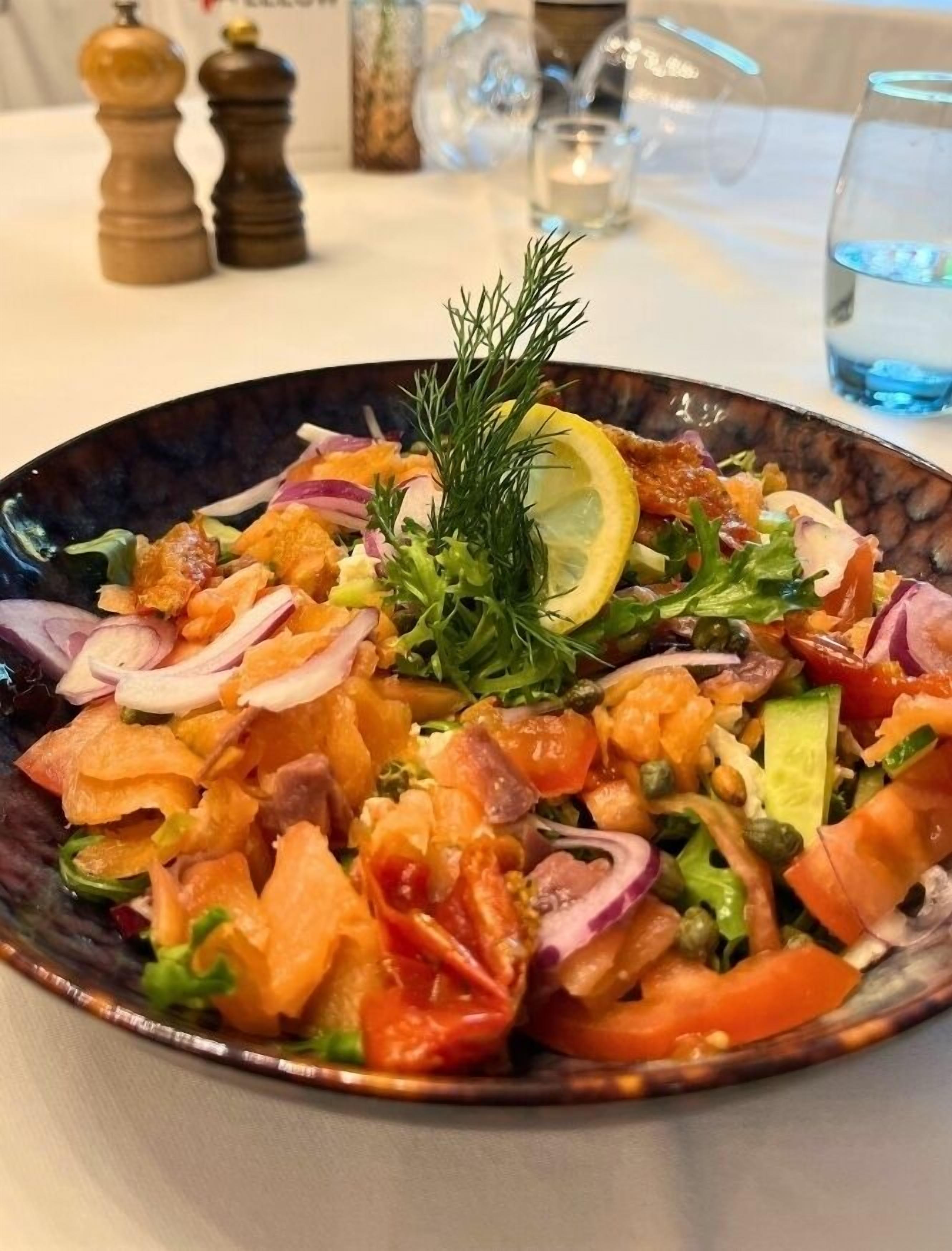 Uma salada com vários vegetais e uma fatia de limão por cima.