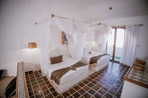 Quarto com duas camas, uma janela grande e piso em azulejos.