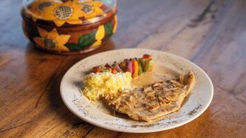 Uma mesa de madeira com um prato de comida e um pote decorativo.