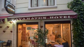 Exterior do Hotel Taya Hatun, com uma entrada ampla, plantas em vasos e área de estar ao ar livre.