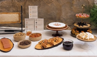 Uma mesa com diversos alimentos, incluindo doces, frutas e um bolo.
