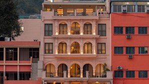 Um hotel com vários andares, varandas, janelas amplas e vista para uma colina.