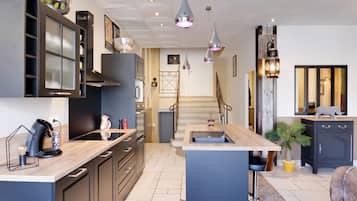 Uma cozinha moderna com ilha central, eletrodomésticos embutidos e iluminação pendente.