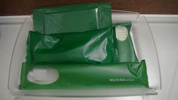 Bandeja branca com produtos de higiene verde, incluindo escova de dentes e sabonete em barra.