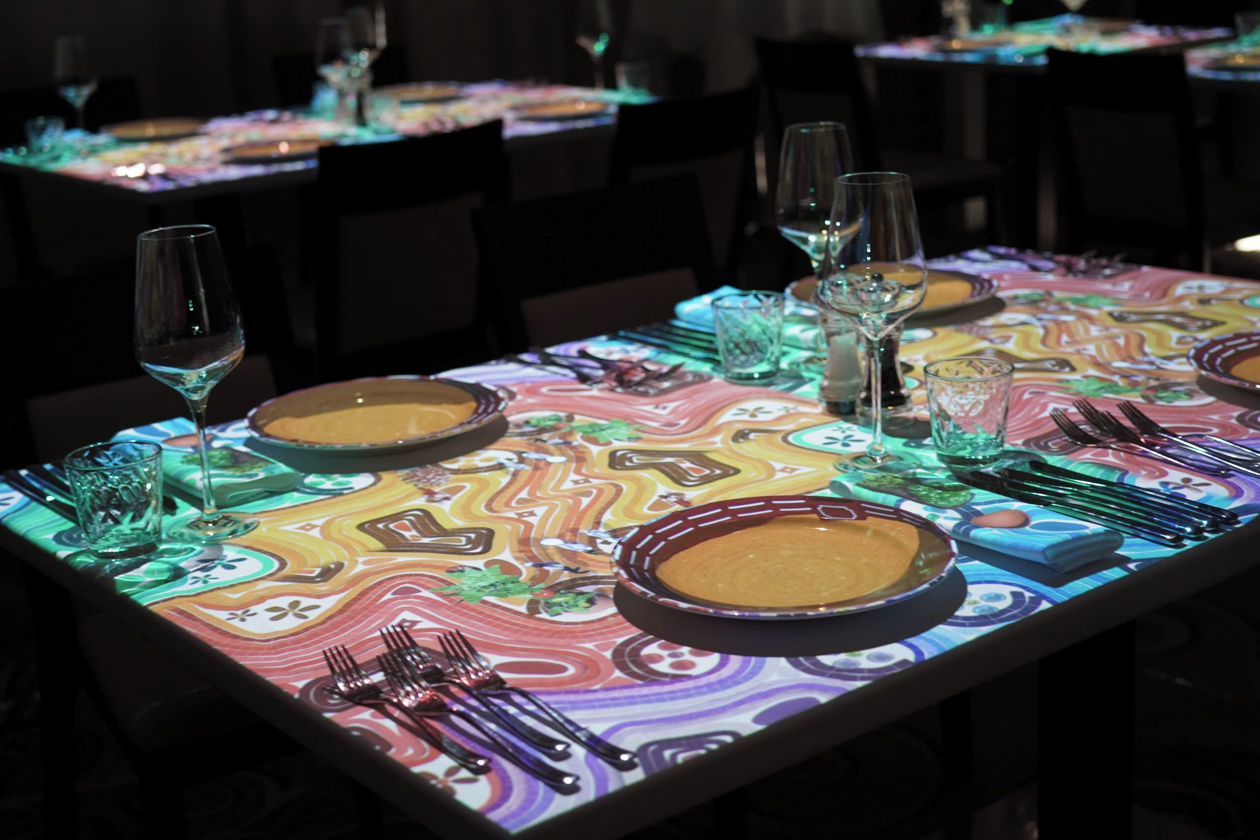 Uma mesa de jantar posta com pratos, copos e talheres.