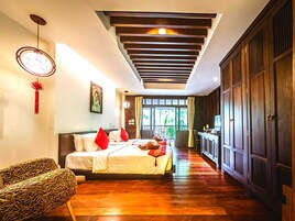 Quarto de hotel com cama, uma cadeira, uma escrivaninha e vista para o exterior.