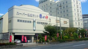 Um edifício com uma placa que diz "Super Health Land" e outra placa acima com a inscrição "Hotel".