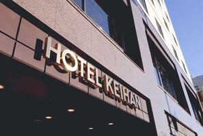 Um letreiro de hotel com o nome 'HOTEL KEIHAN' em letras grandes.