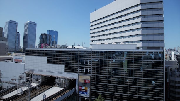 Um edifício moderno com a placa Keihan no topo.