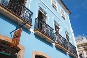 Um edifício azul com varandas e uma placa que diz 'Solar'.