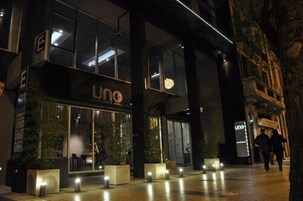 Um edifício moderno com fachada de vidro e o nome "UNO" em destaque.