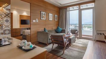 Suíte júnior, 1 quarto, vista para a cidade | Área de estar | TV de tela plana 31 polegadas com canais via satélite, TV