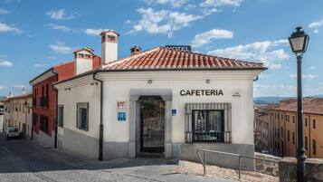 Um edifício com uma placa que diz “CAFETERIA” e “HOTEL” em cima.