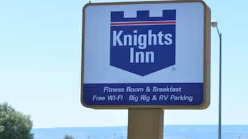 Placa da Knights Inn com comodidades como academia, café da manhã, Wi-Fi gratuito e estacionamento para veículos grandes e trailers.