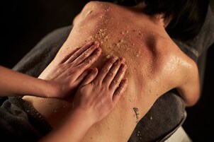 Close-up de mãos fazendo massagem nas costas de alguém.