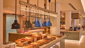 Buffet com diversos alimentos e uma torradeira.