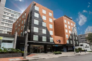 Um hotel moderno com um design angular único, com vários andares e fachadas de tijolo e vidro.