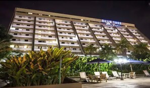 Um hotel com design moderno, com vários andares e uma placa chamativa com a inscrição "BLUE TREE HOTEL".