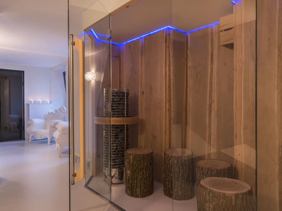 Um interior moderno com divisória de vidro, painéis de madeira e uma escadaria.