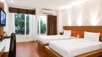 Quarto de hotel com duas camas, uma escrivaninha e uma televisão.