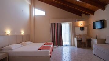 Quarto de hotel com duas camas, uma mesa, televisão e chuveiro.