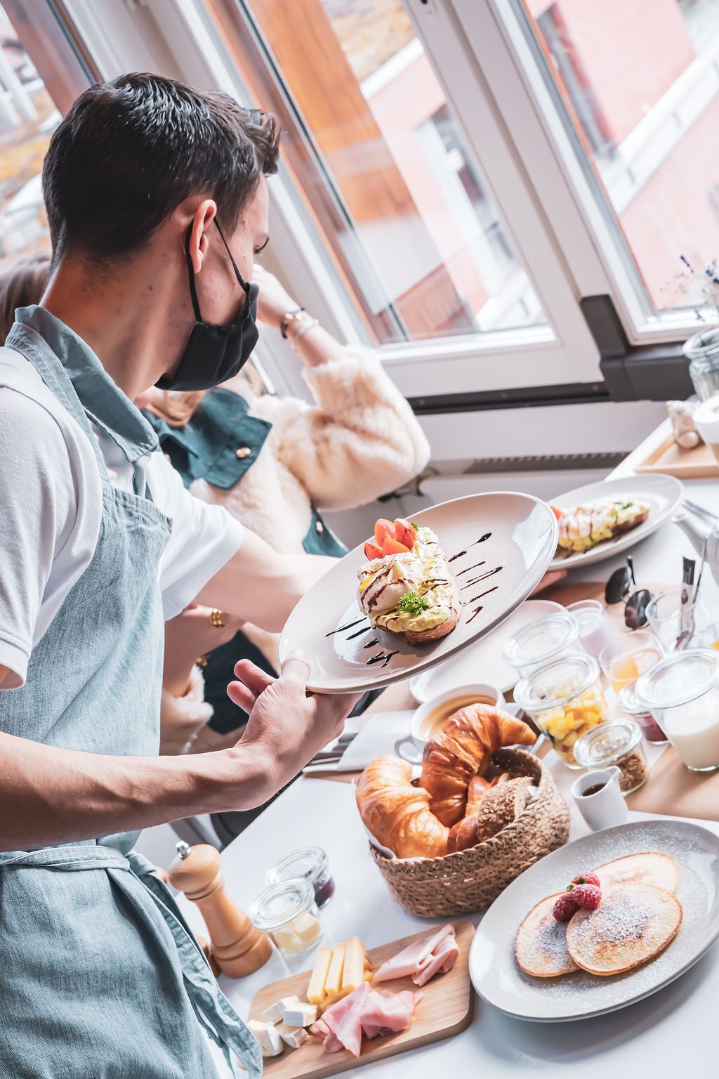 Um buffet de café da manhã com diversas opções de comida, incluindo doces, frutas e diferentes tipos de patês.