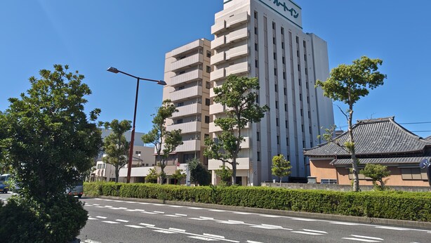 Um edifício de vários andares com uma placa indicando que é um hotel.