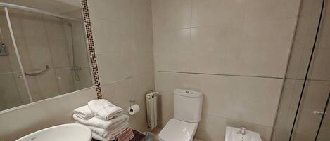 Uma casa de banho moderna com uma grande pia, sanita e bidé.