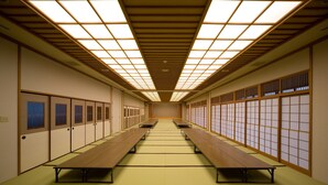 Um quarto japonês tradicional com tatames, portas deslizantes e uma longa mesa de madeira.