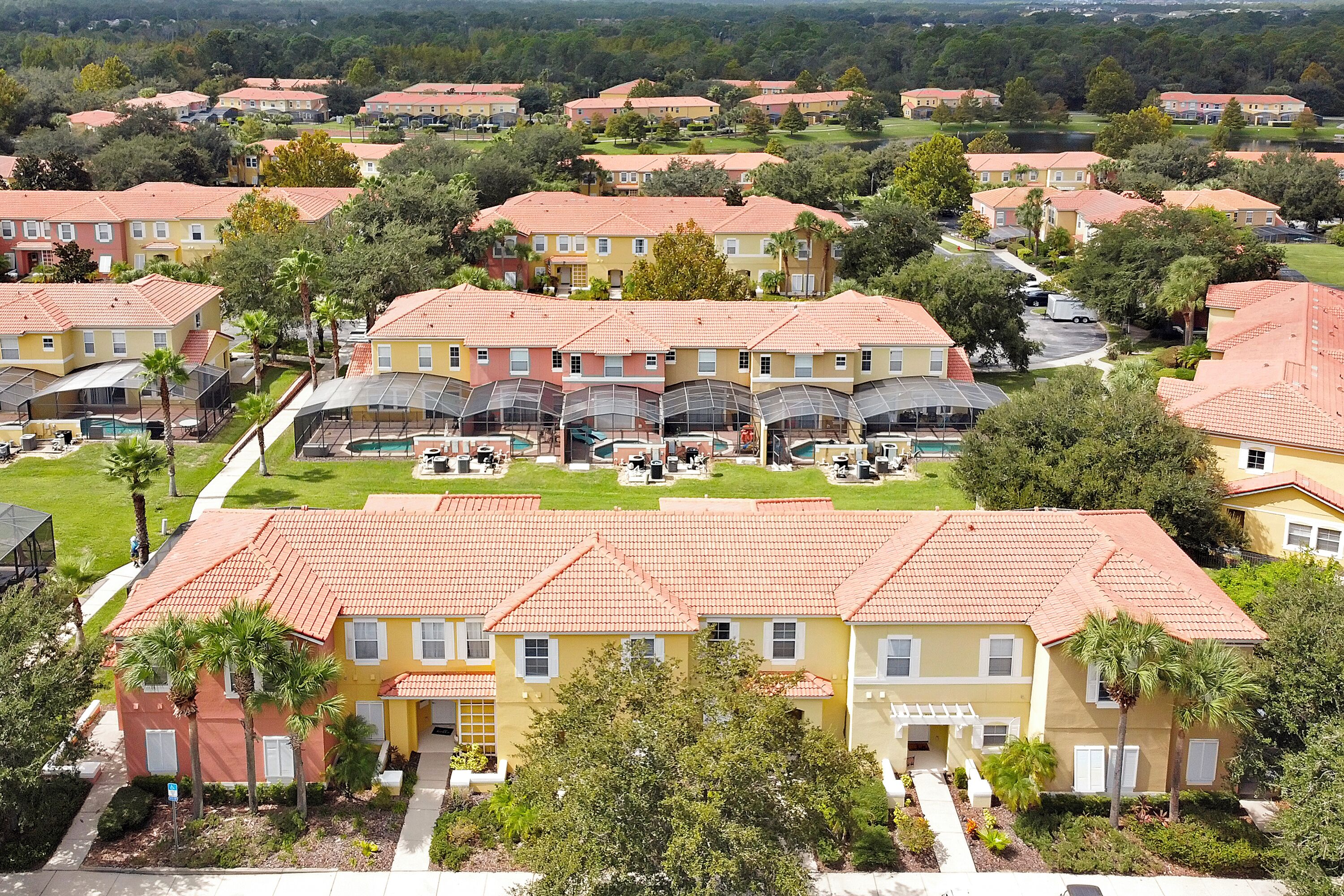 Um bairro residencial com várias casas de dois andares, telhados vermelhos e fachadas amarelas.