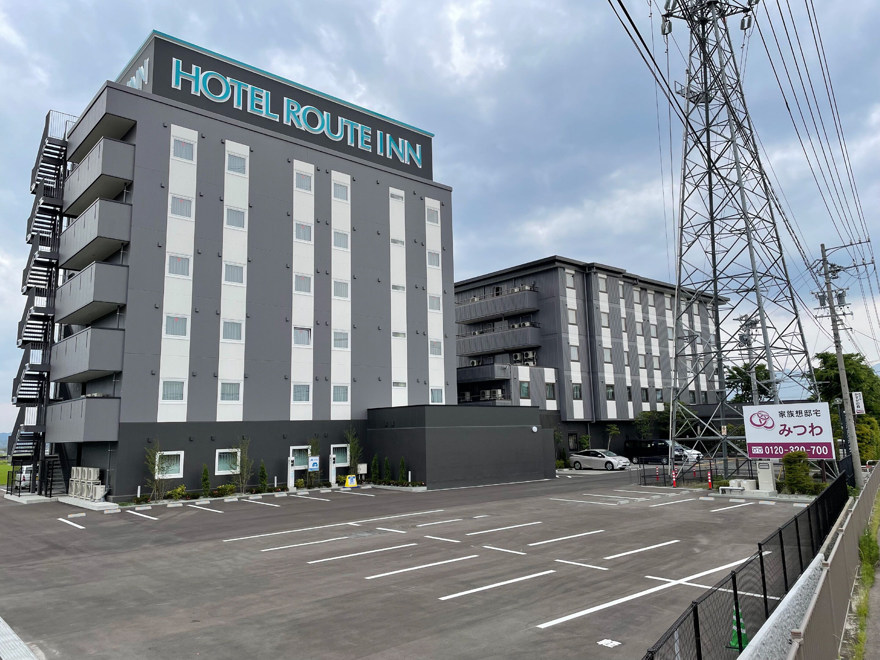 Um edifício de hotel moderno com uma placa que diz 'HOTEL ROUTE INN'.
