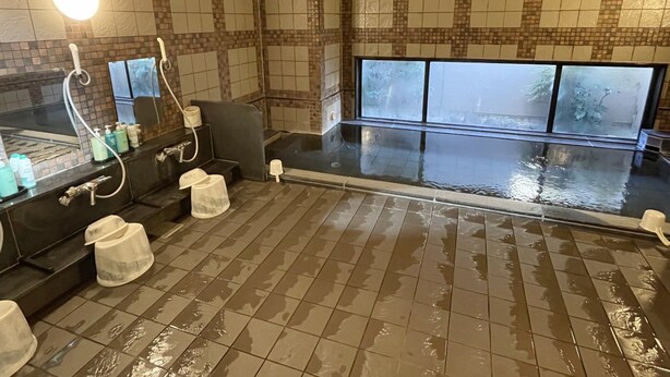 Uma casa de banho húmida com um espelho grande, uma pia e uma banheira.
