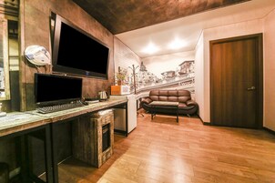 Um quarto acolhedor com uma escrivaninha de madeira, uma TV de tela plana, um sofá de couro e um mural com uma vista urbana.