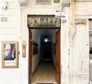 Entrada de hotel com uma placa indicando "BOLAFI" e portas numeradas 22 e 23.